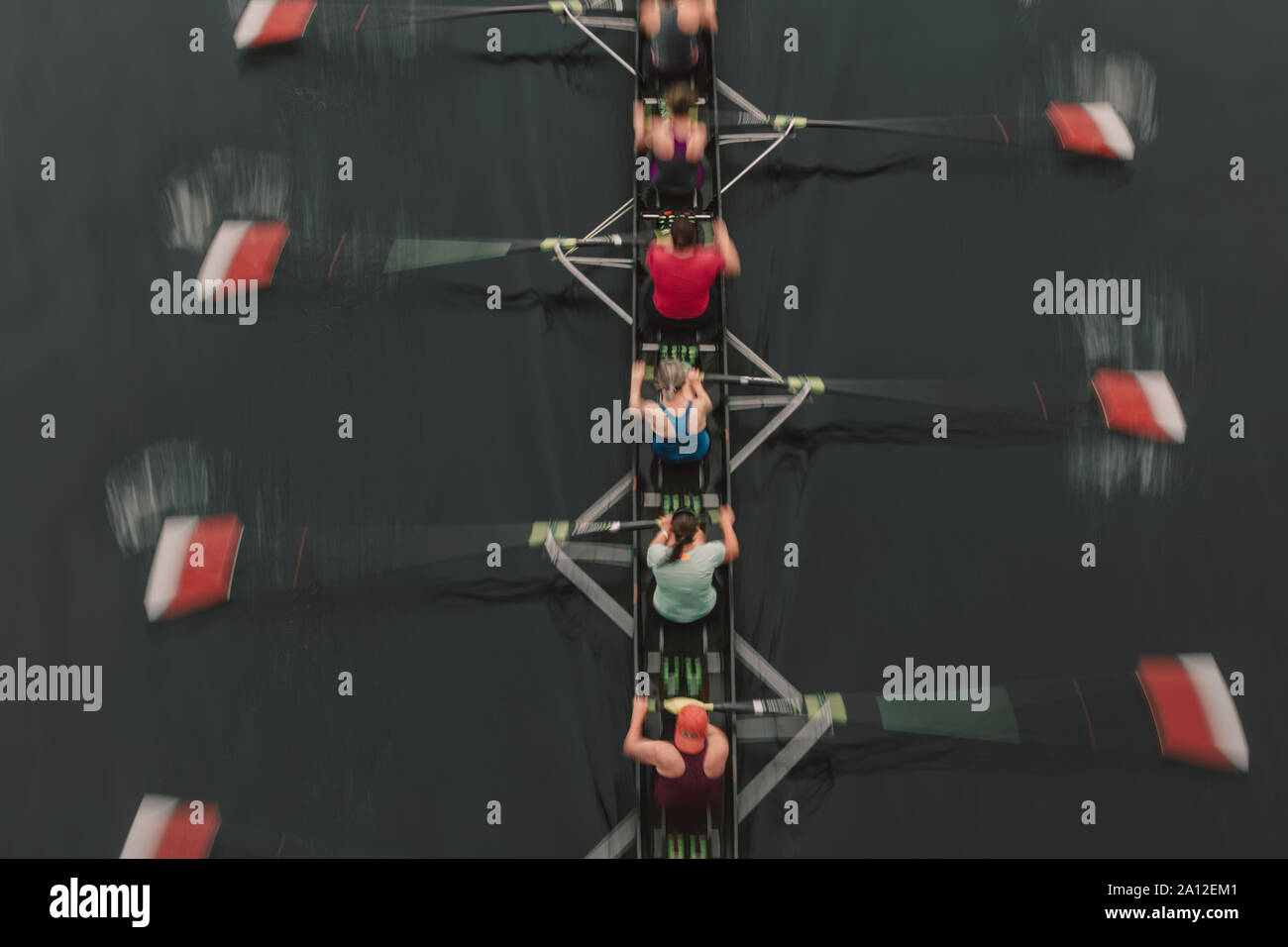 Blurred motion overhead view of a rowing crew in a sculling boat on the ...