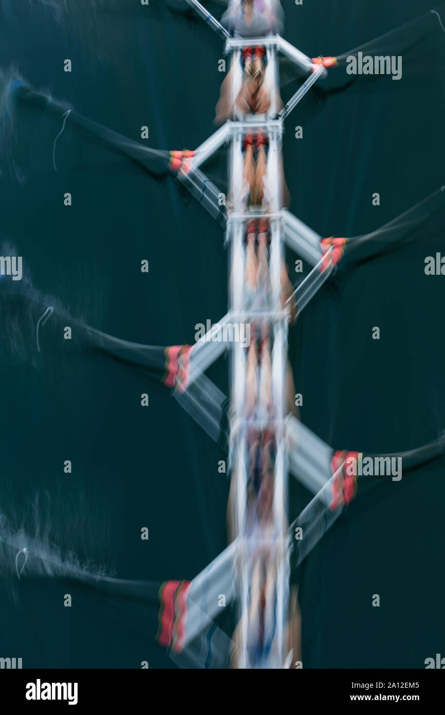 Blurred motion overhead view of a rowing crew in a sculling boat on the ...