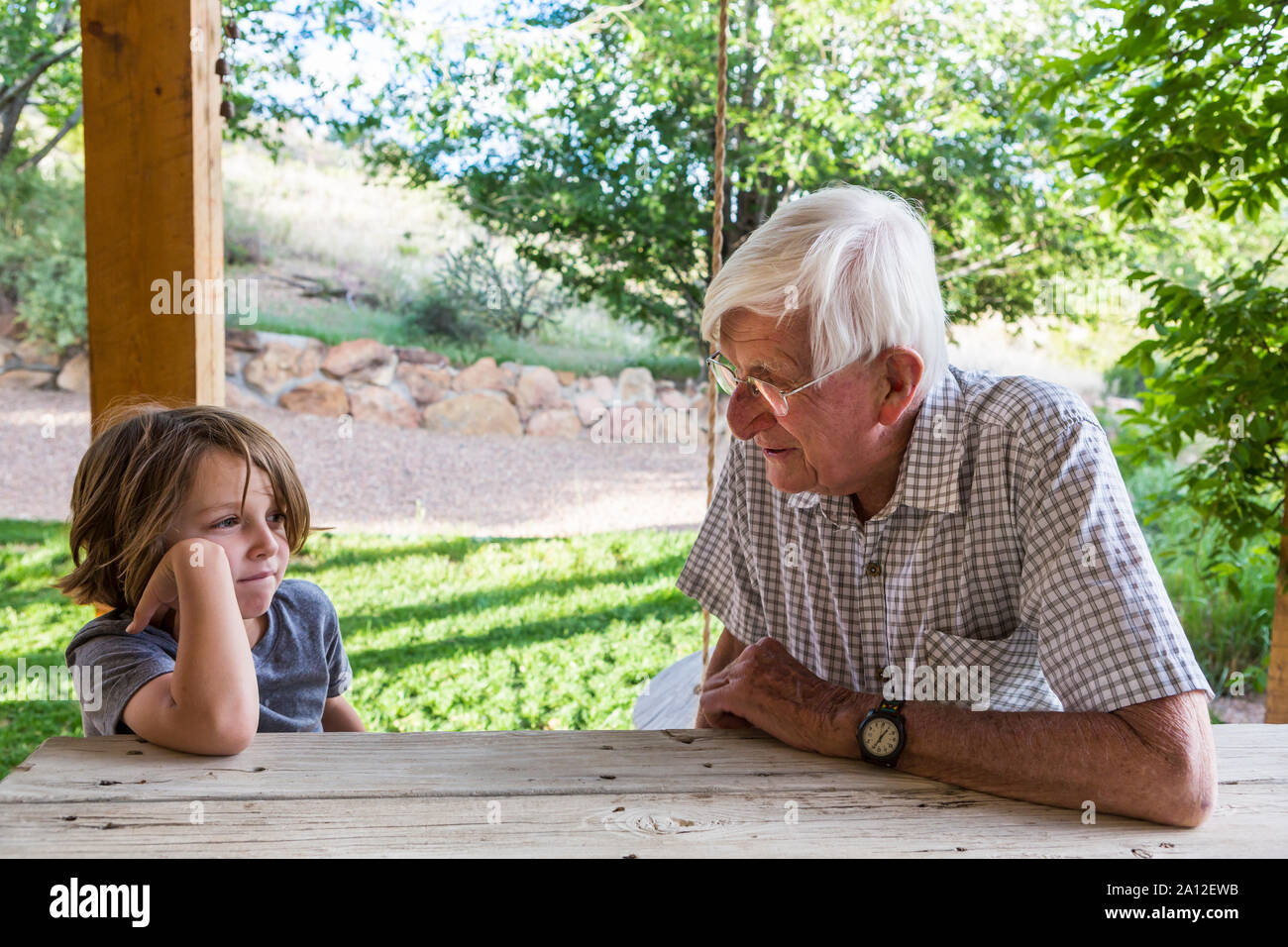 A grandfather and grandson sitting talking Stock Photo - Alamy