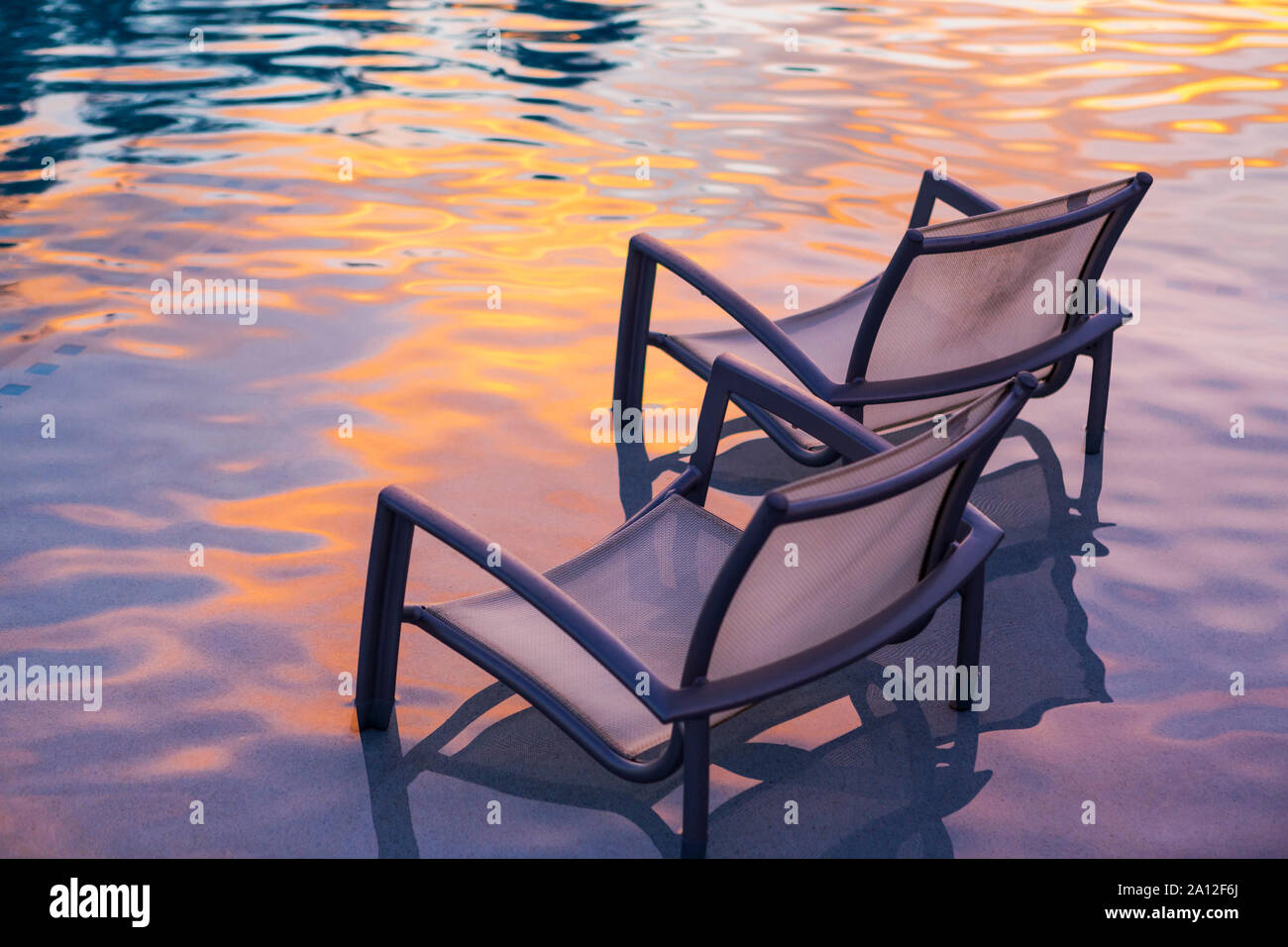 beach chair in pool at sunset Stock Photo - Alamy