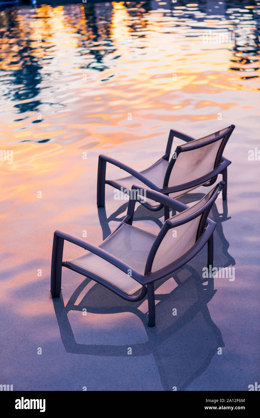 beach chair in pool at sunset Stock Photo - Alamy