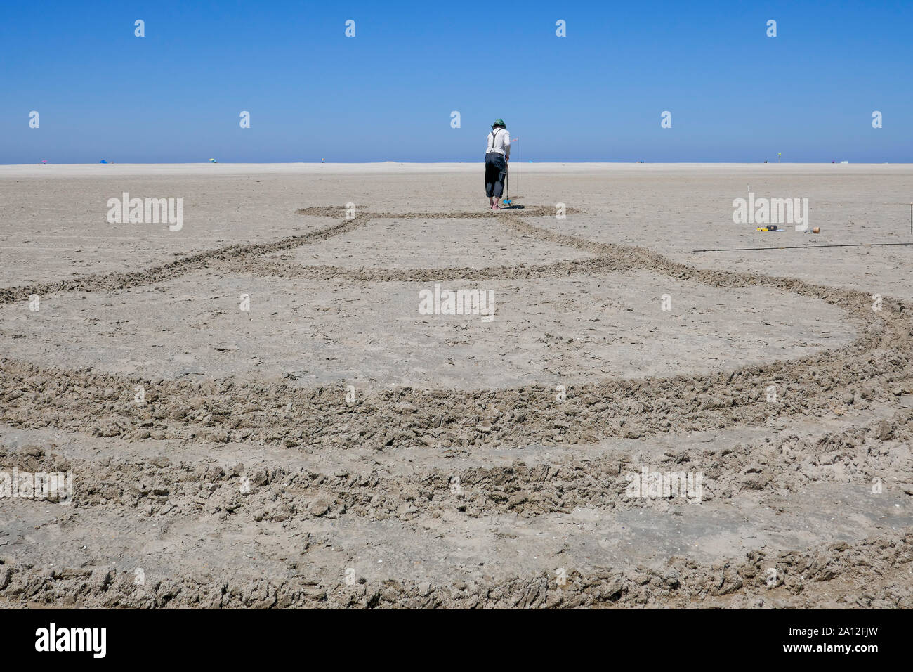 drawing anamorfose in the sand at the beach in Holland Stock Photo - Alamy