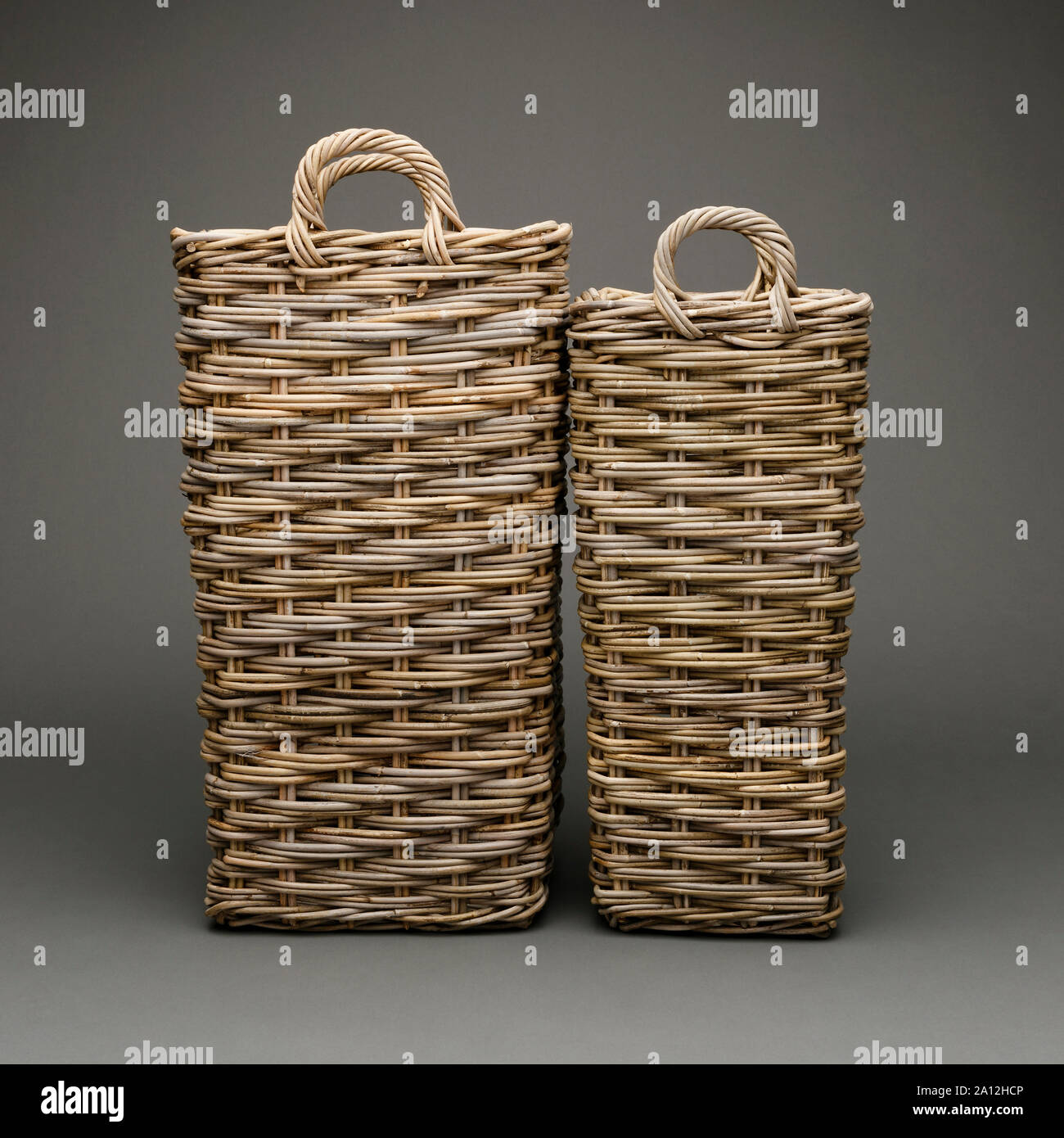 Twol natural wicker basket, with a grey background, and a drop shadow ...