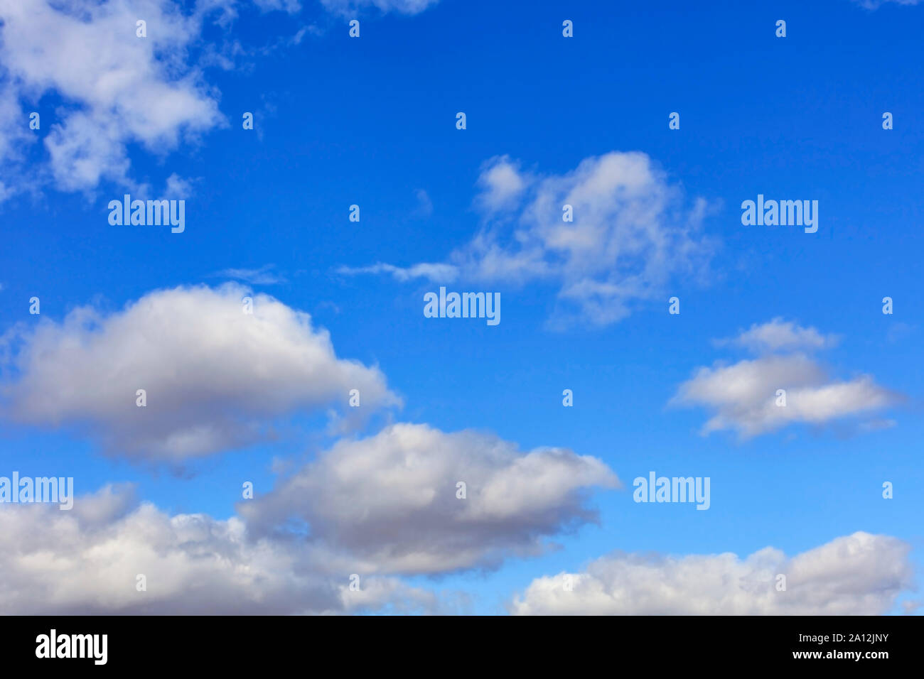 Blue sky background with the texture of white and fluffy, fun clouds ...