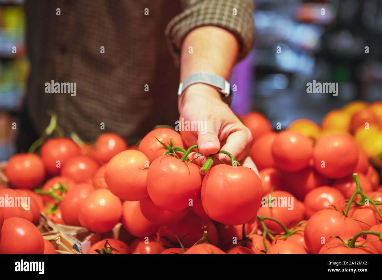 man hand choosing red tomatoes in grocery store Stock Photo - Alamy