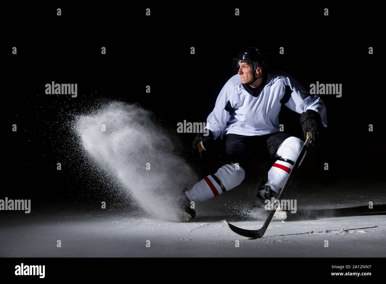 Ice hockey player in action kicking with stick Stock Photo - Alamy