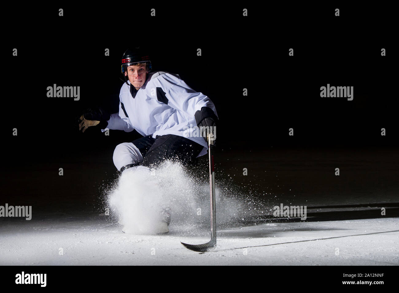 Ice hockey player in action kicking with stick Stock Photo - Alamy