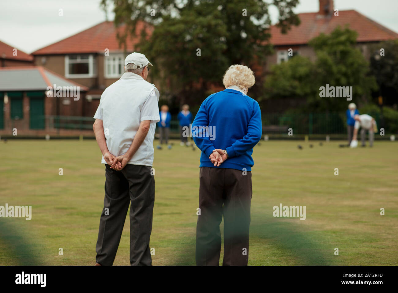 A rear view shot of a senior couple spectating a lawn bowling game ...
