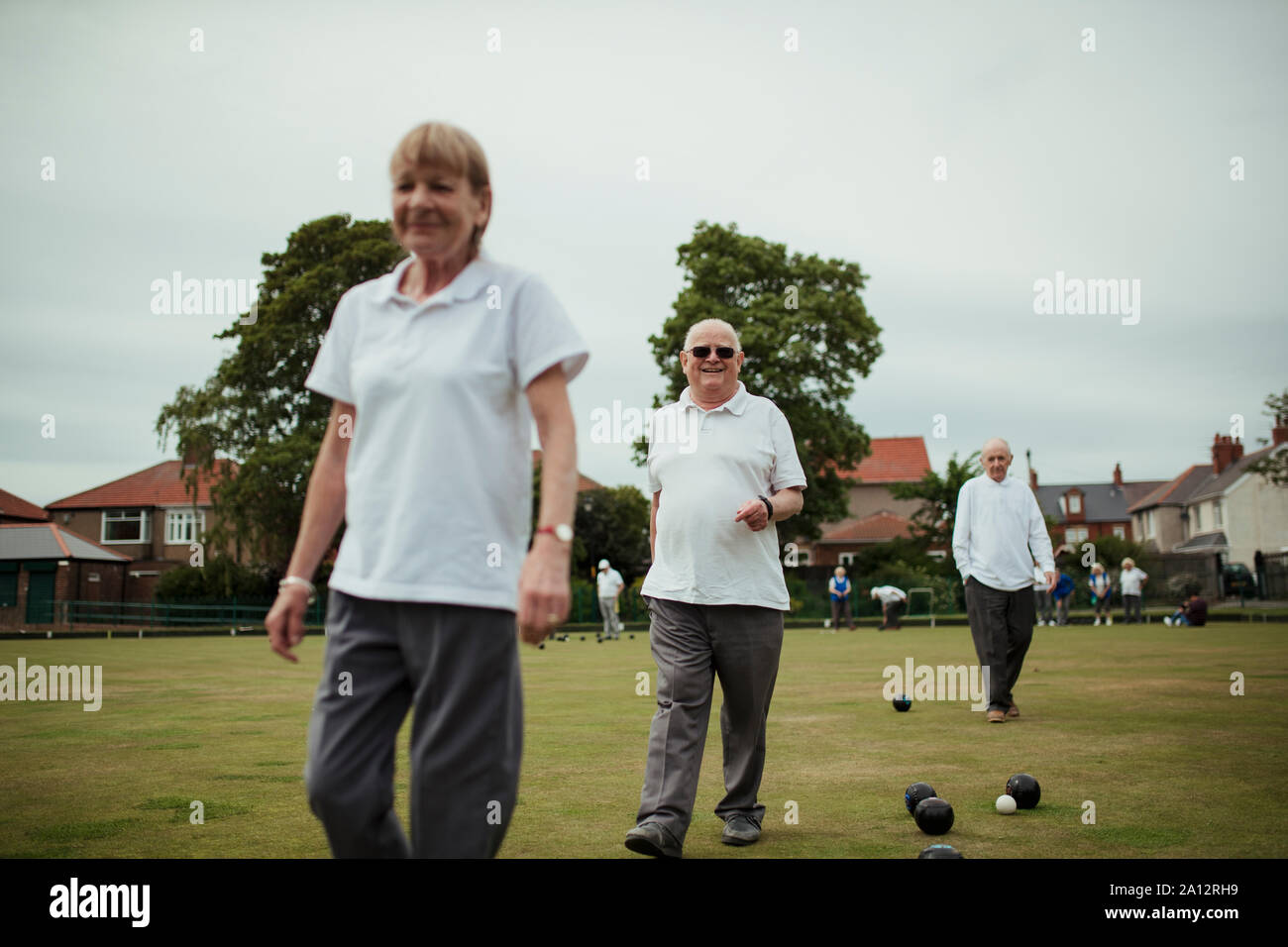 A front view shot of a group of seniors walking in a line at a bowling ...