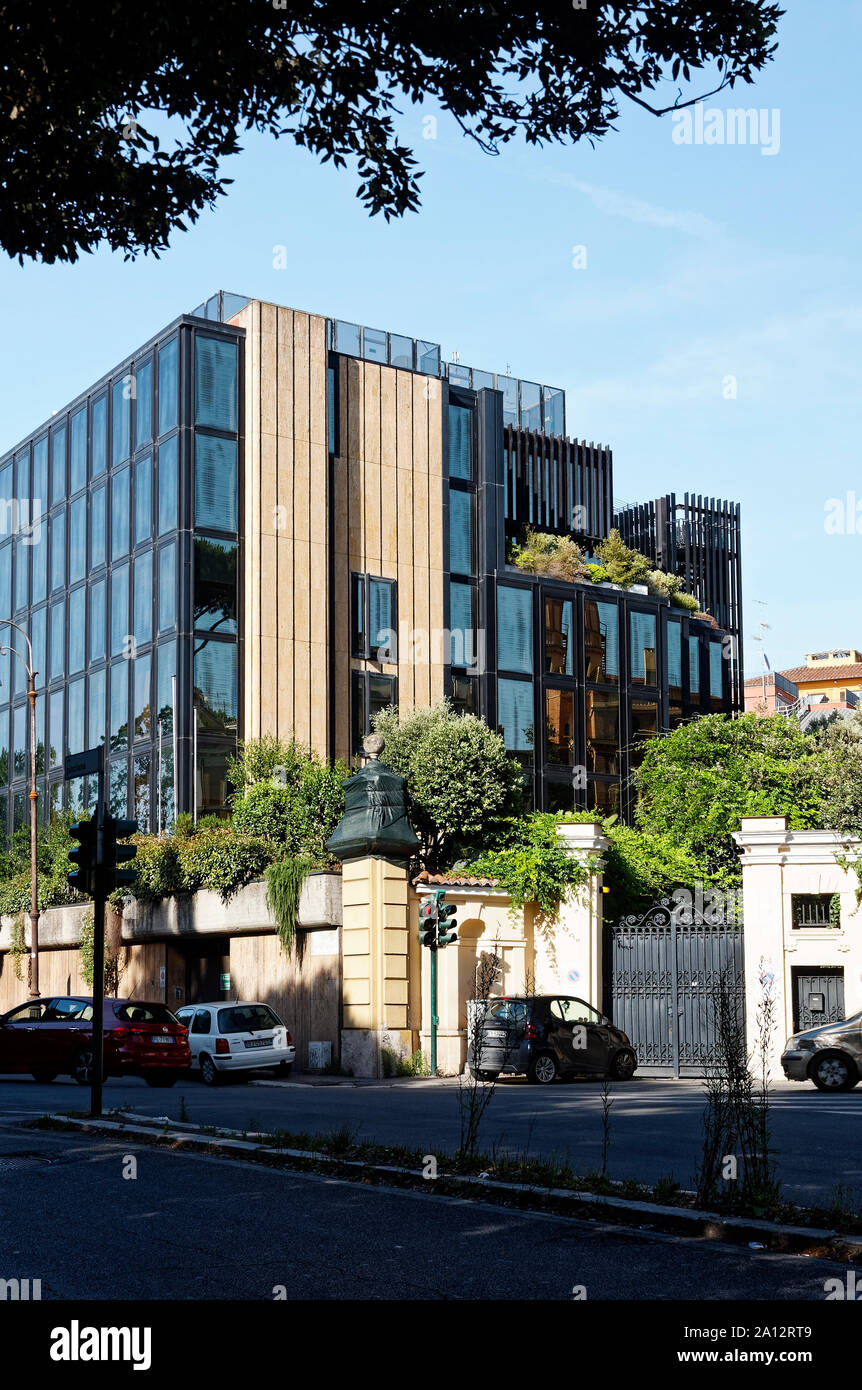 modern building; mostly glass, cars parked, wrought iron gate ...