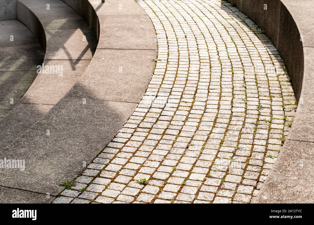 detail of urban footpath with sett stone pavement and concrete steps ...