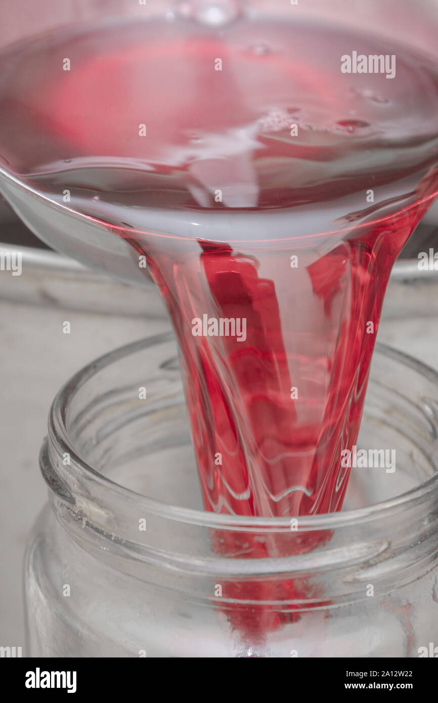 Pouring hot syrup from a ladle into a glass jar Stock Photo - Alamy