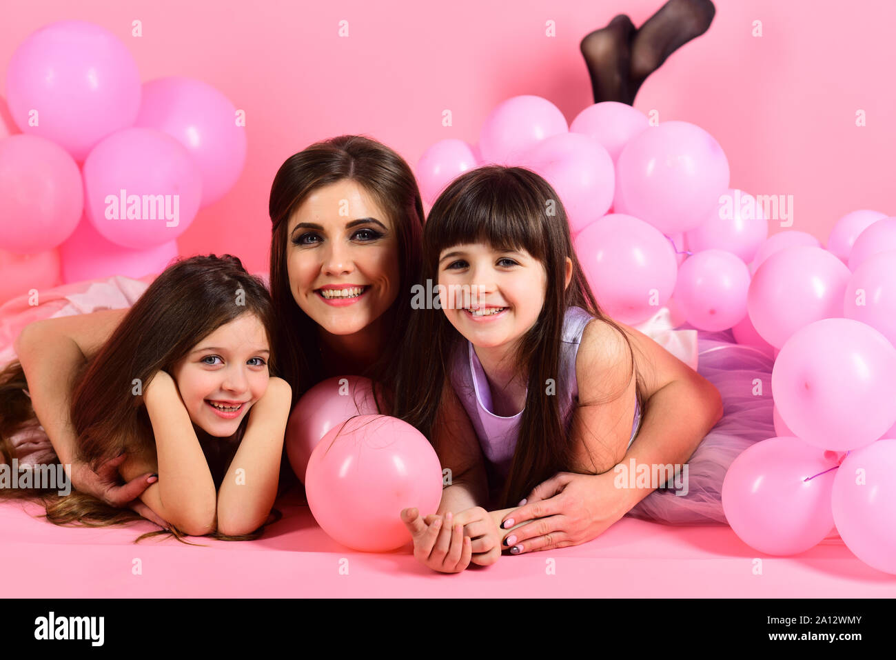 Funny family on a background of bright pink wall. Mother and her ...