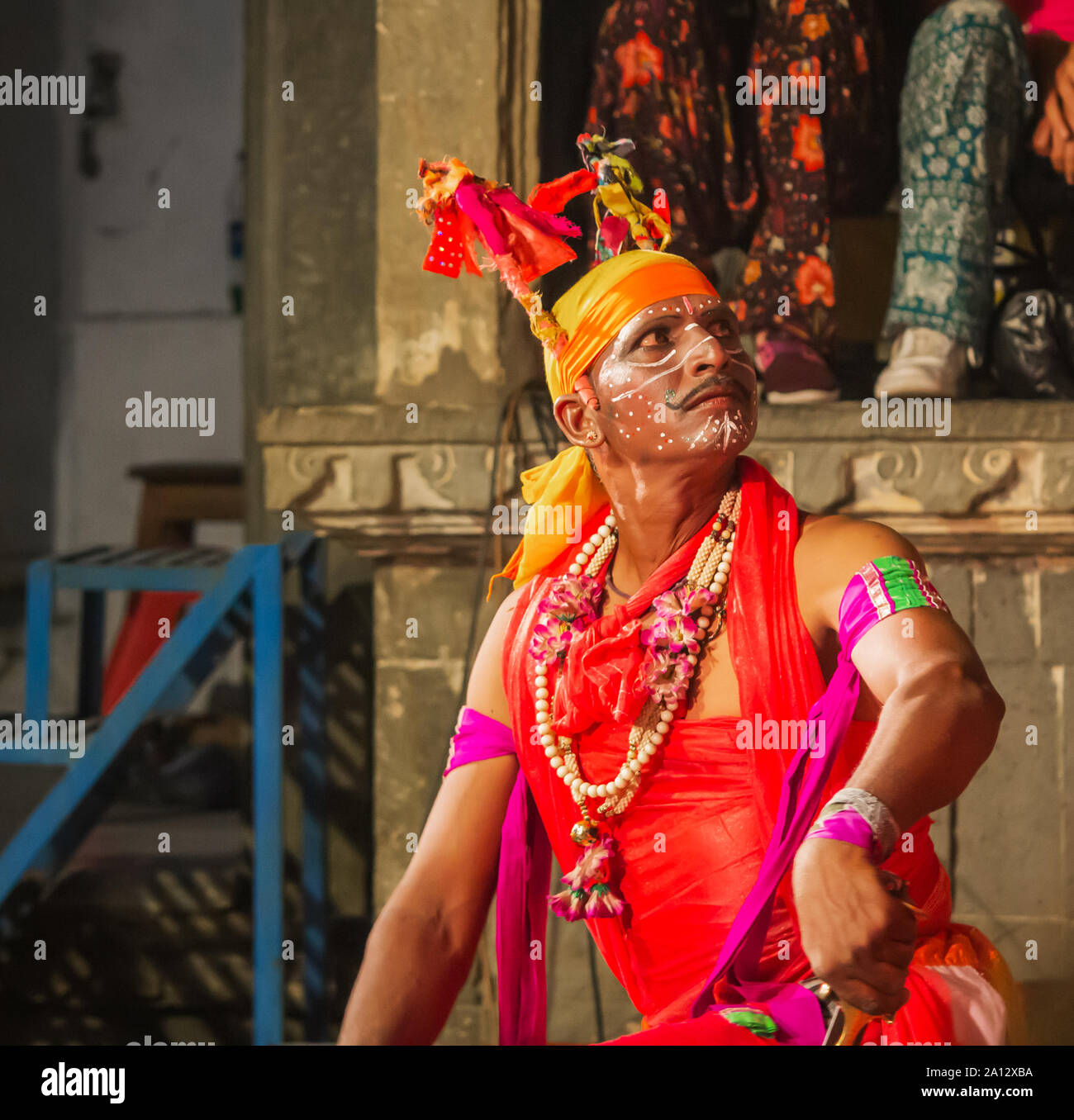 Man dressed in colourful apparel acting in a theatre drama as a Indian ...