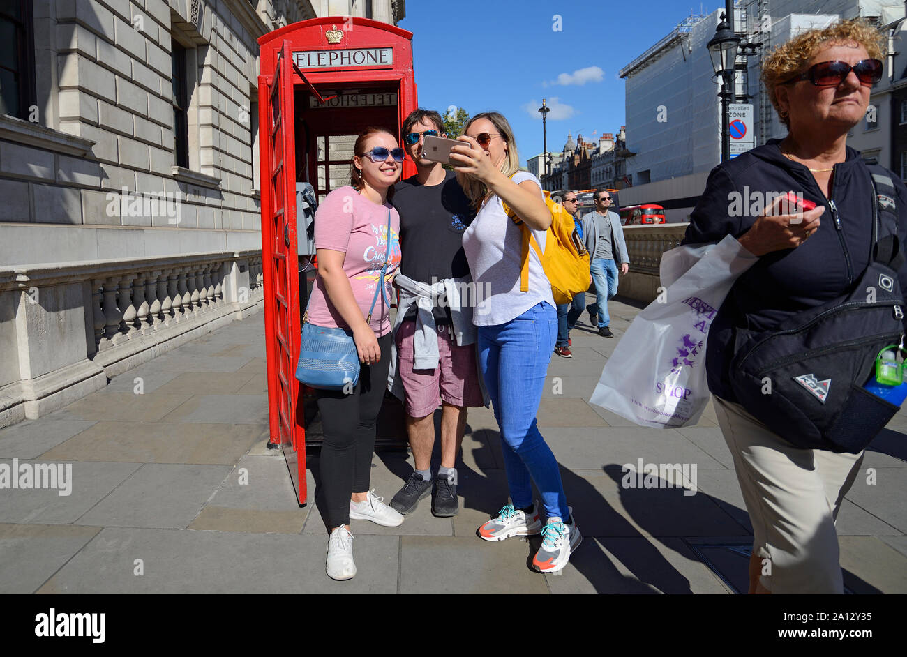London, England UK. Three friends posing for a selfie by a traditional ...