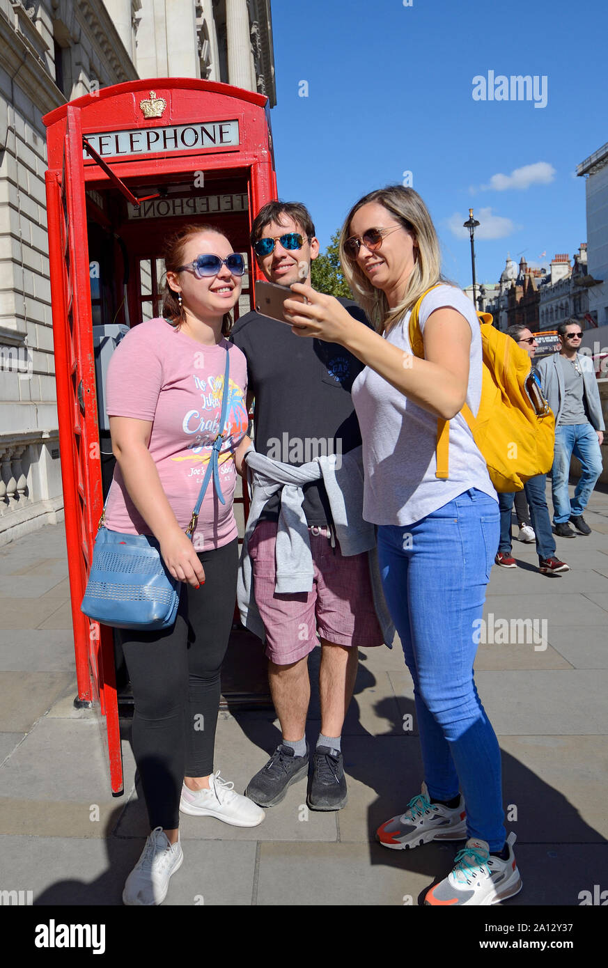 London, England UK. Three friends posing for a selfie by a traditional ...