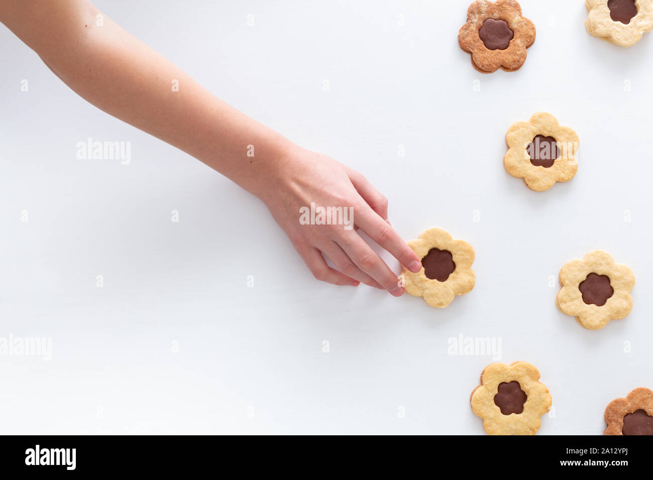 Child's hand reaching for homemade cookies, all on white background ...