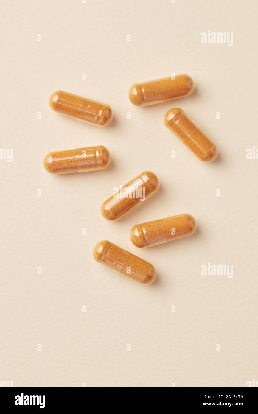 Turmeric capsules. Bright paper background. Top view. Copy space Stock ...