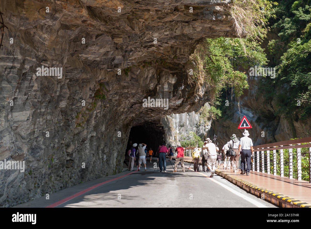 A group of photographers trying to take shot of cliffside tunnel on ...