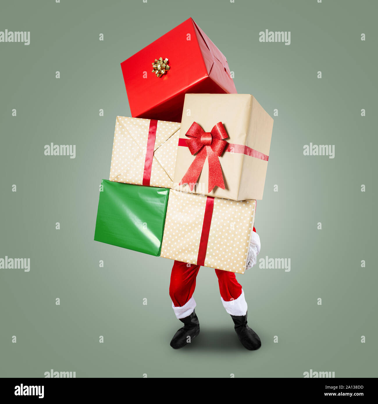 Santa Claus carrying a big pile of Christmas presents Stock Photo - Alamy