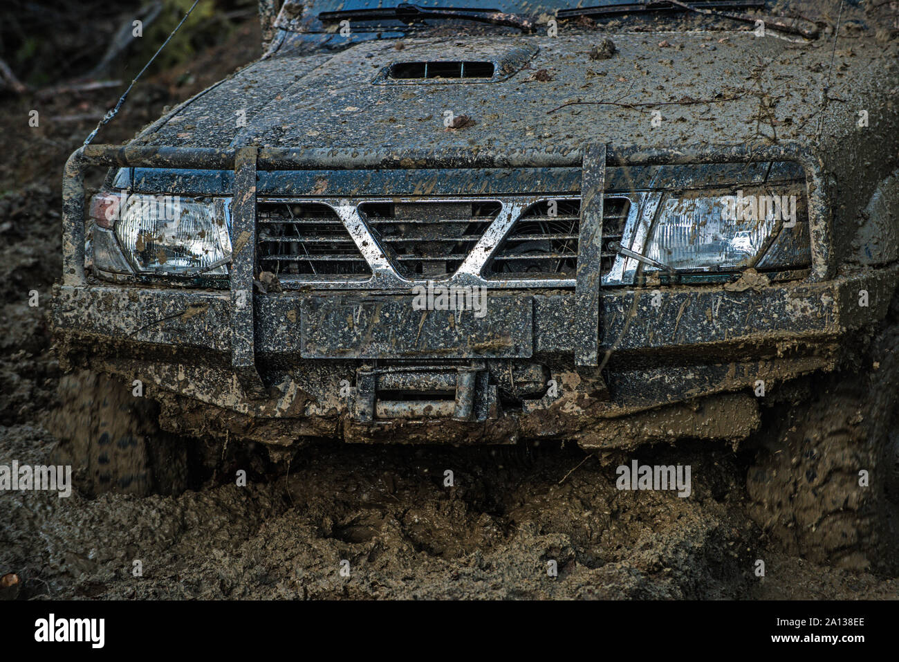 Part of offroad car stuck in deep mud on dark background. Bonnet ...