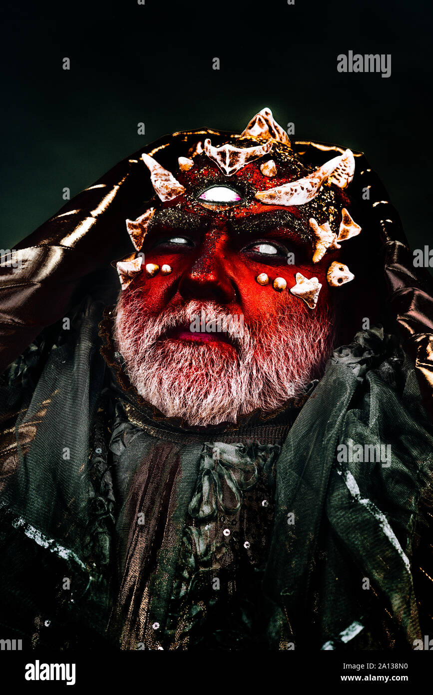 Monster with sharp thorns and warts on bearded face. Furious demon with ...