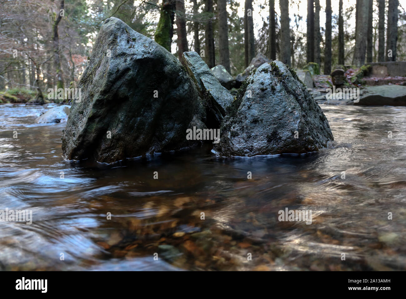 Large rocks in the middle of a woodland stream Stock Photo - Alamy