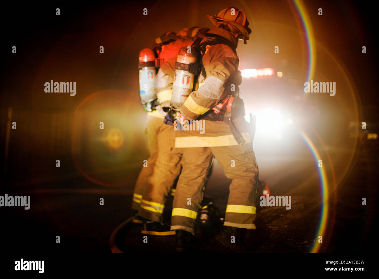 View of vehicles moving towards firefighters Stock Photo - Alamy
