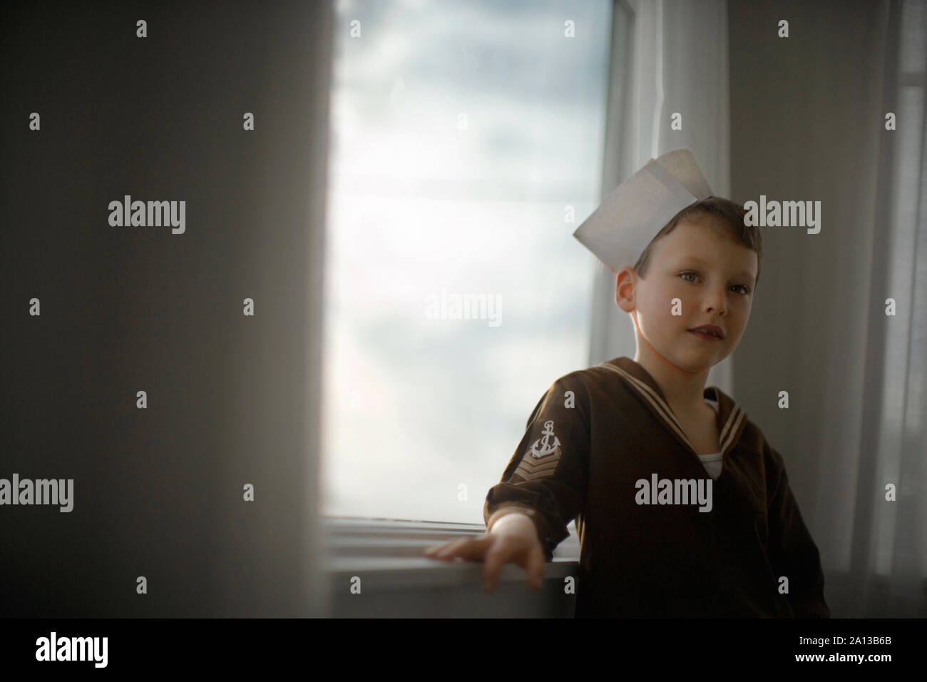 Front view of an adorable little boy standing beside window Stock Photo ...