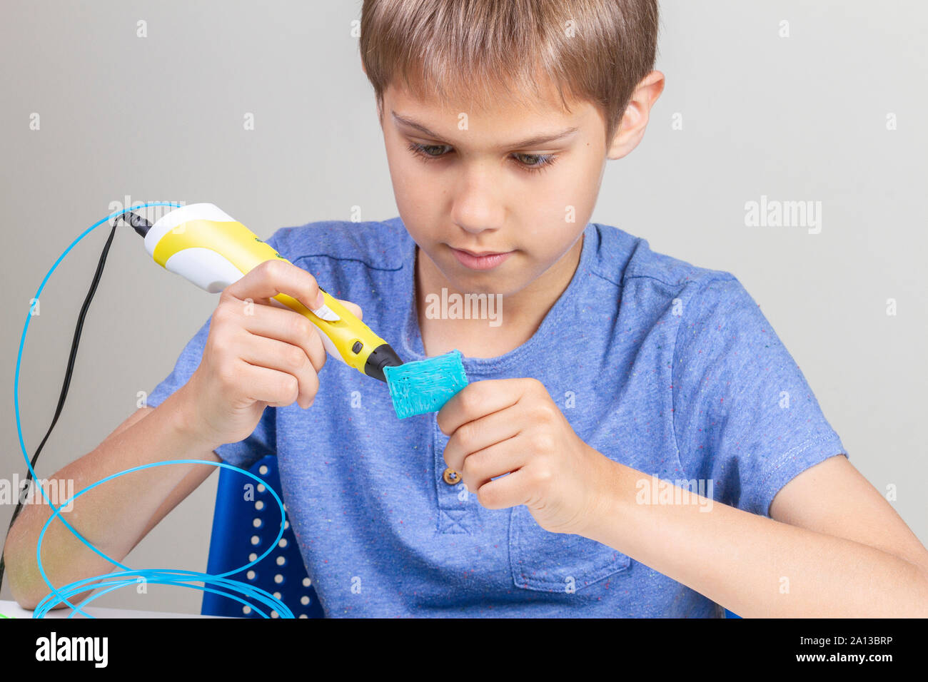 Boy creating with 3d printing pen new item Stock Photo - Alamy