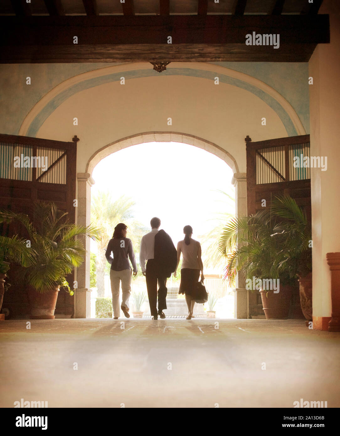 Rear view of three people moving out of a building Stock Photo - Alamy