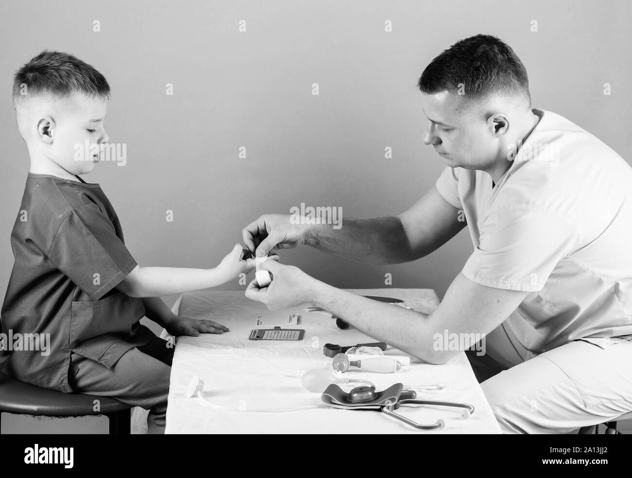 Medical service. Man doctor sit table medical tools examining little ...