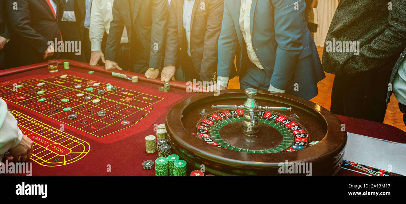 Group of people behind roulette gambling table in luxury casino ...