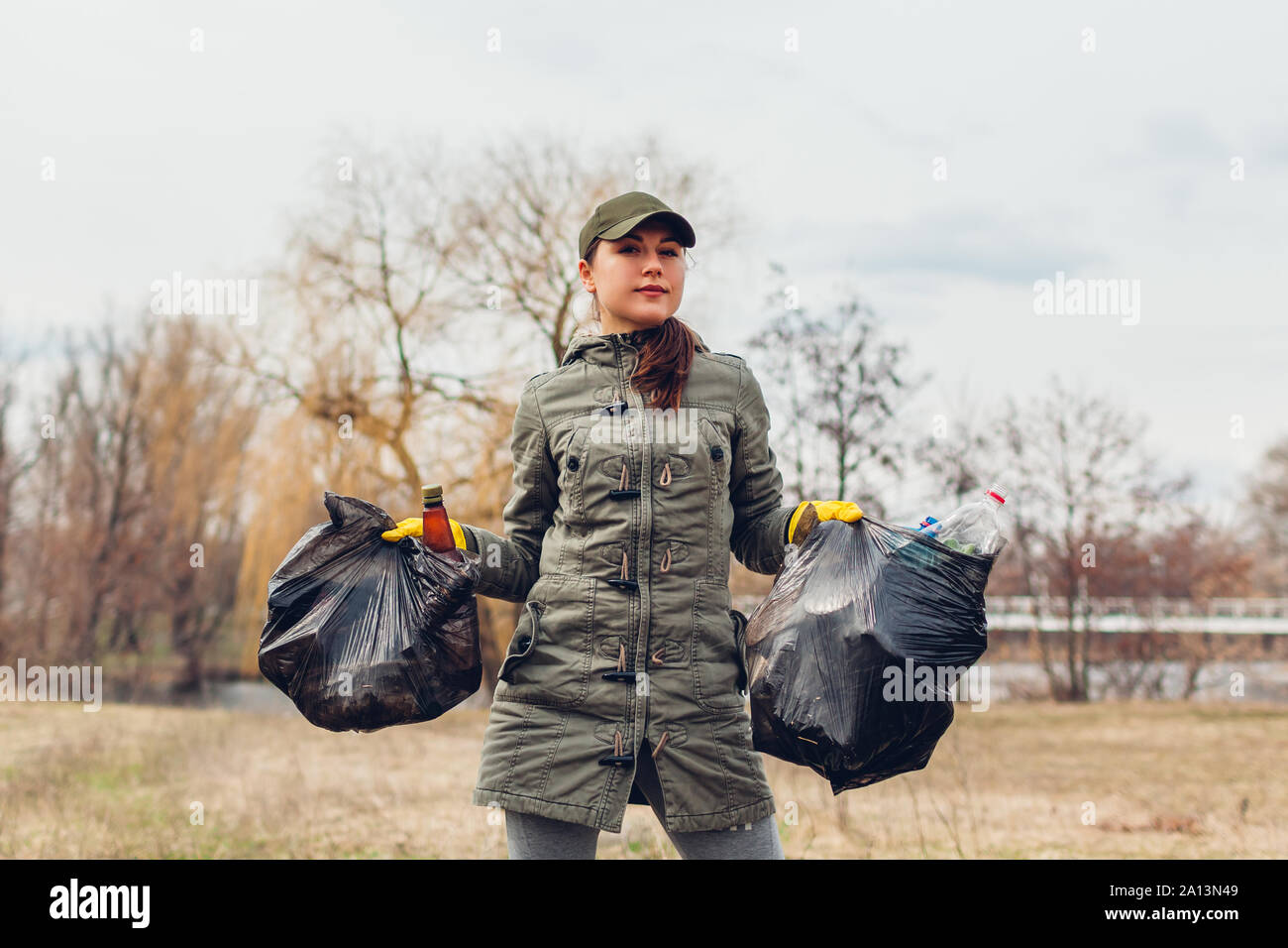 Litter picking. Woman volunteer cleaning up the trash in park. Picking ...