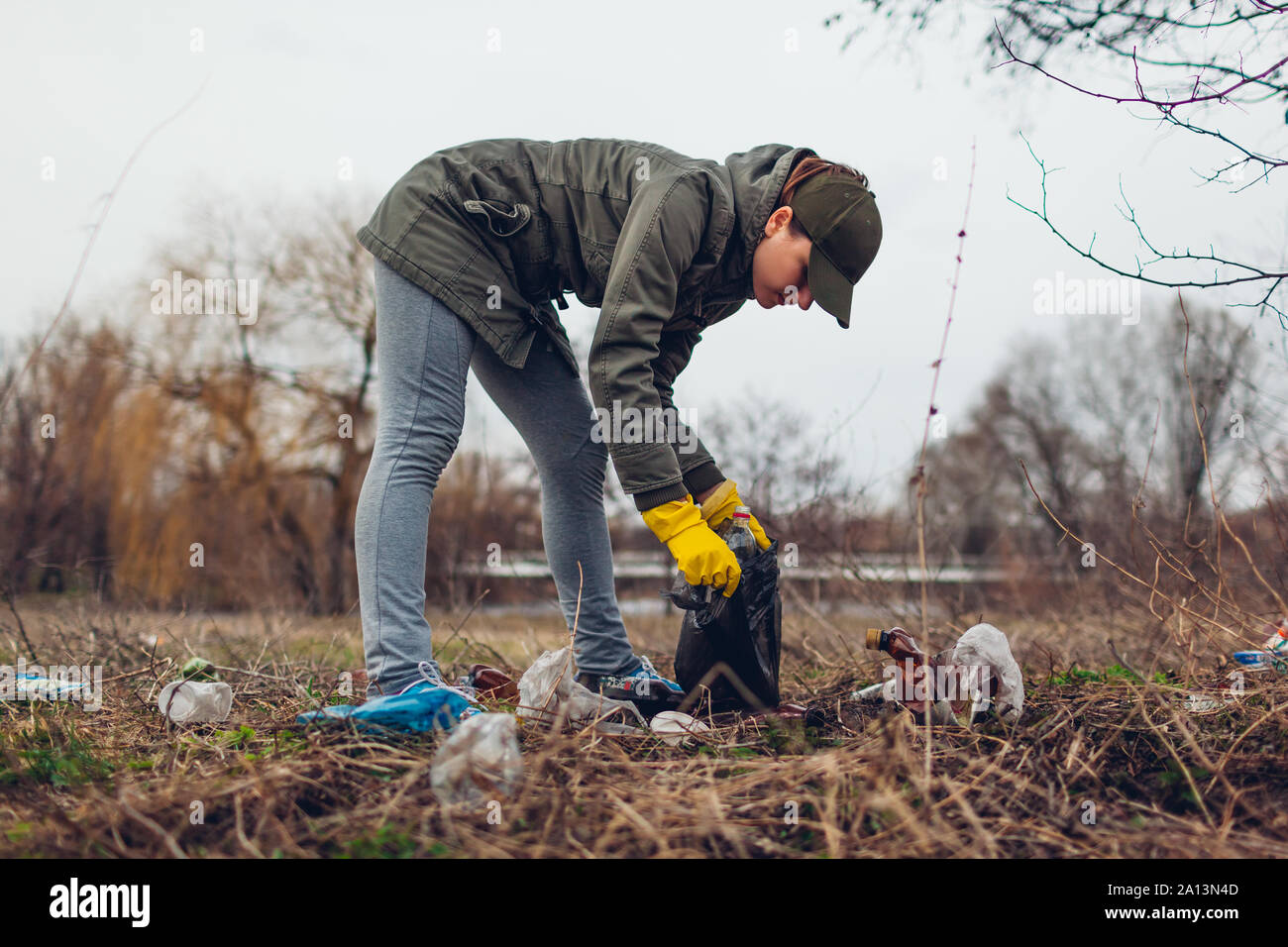 Litter picking. Woman volunteer cleaning up the trash in park. Picking ...