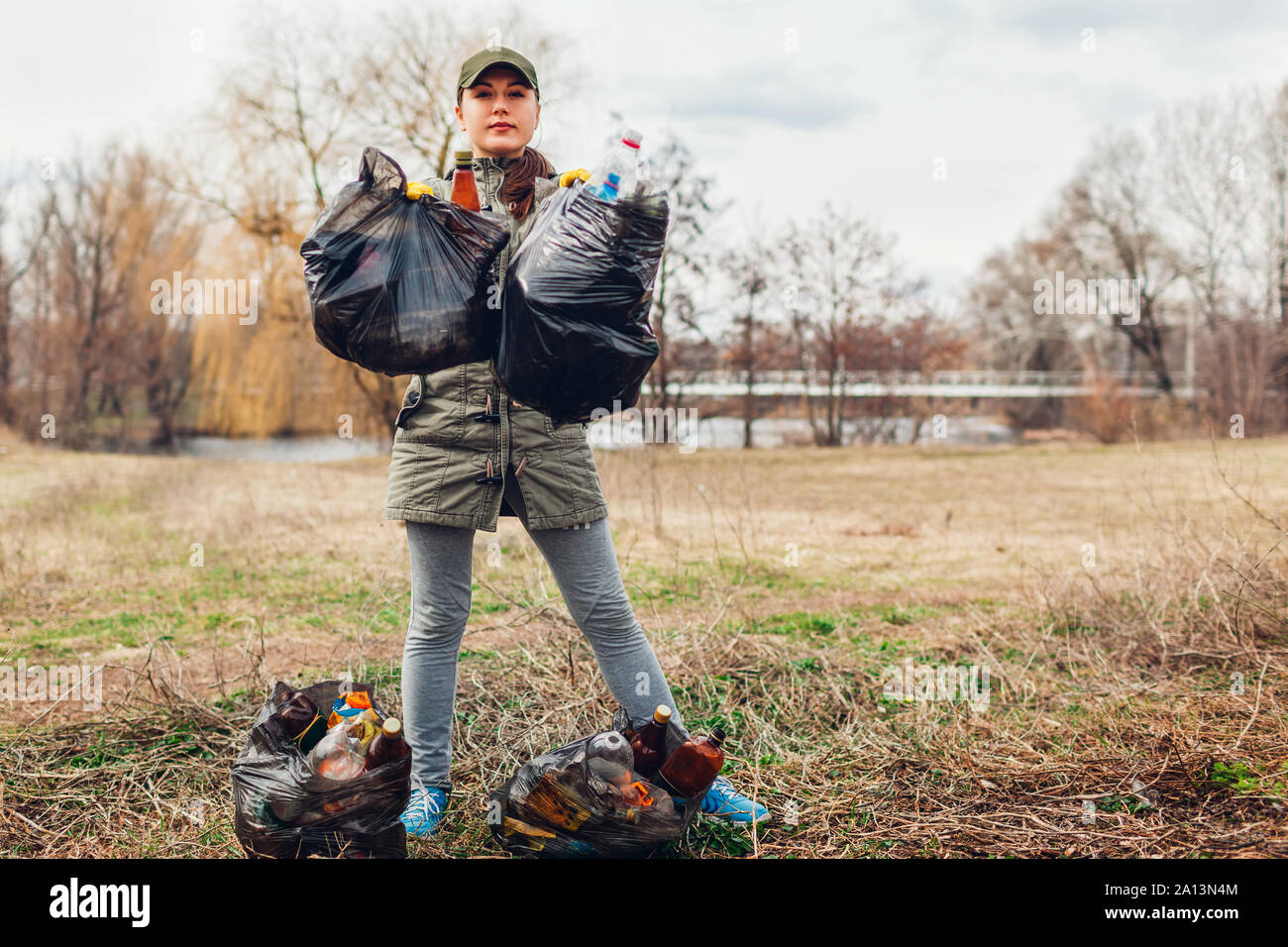 Litter picking. Woman volunteer cleaning up the trash in park. Picking ...
