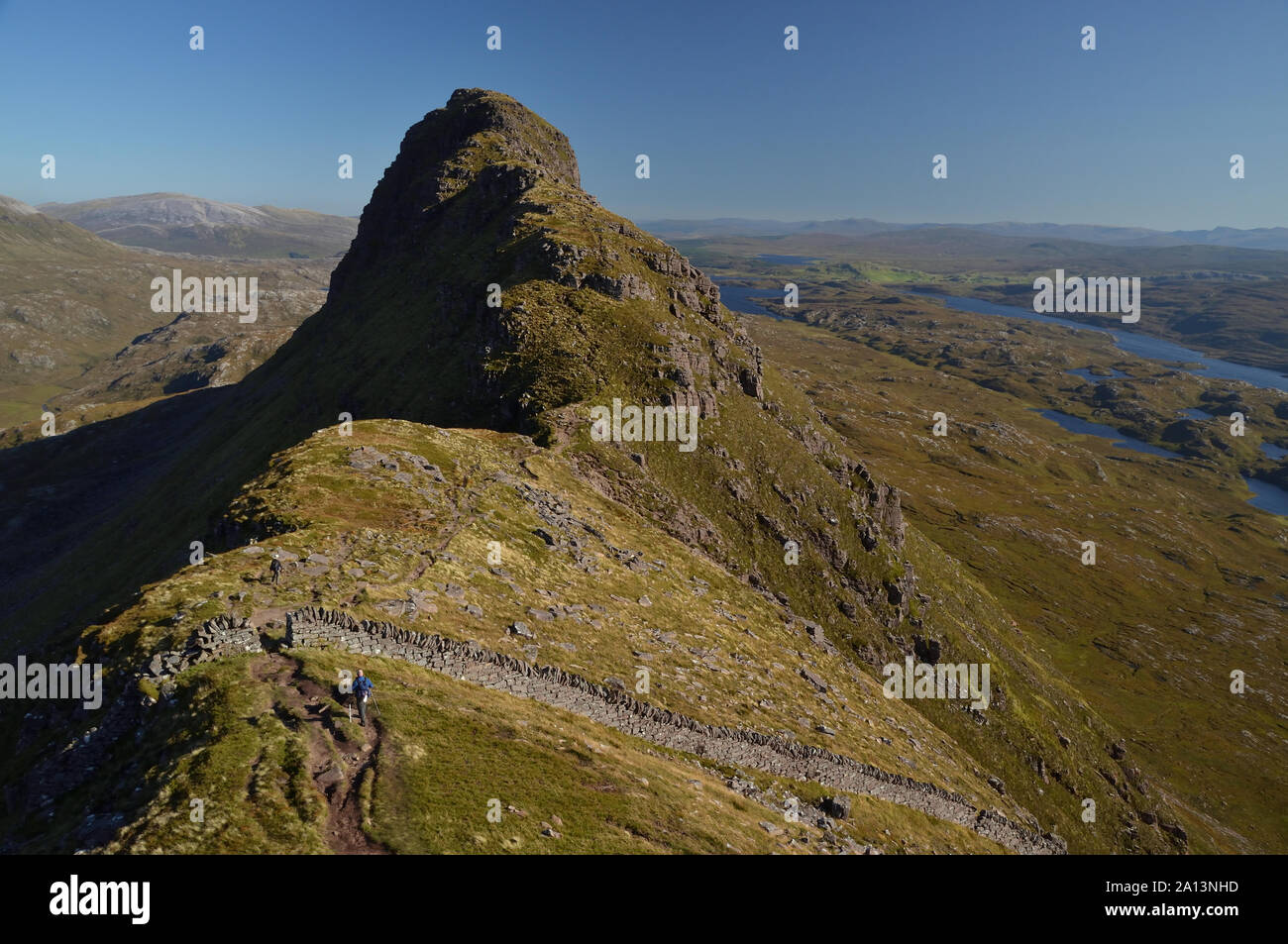 A walker on the ridge path of Suilven, a distinctive hill of the ...