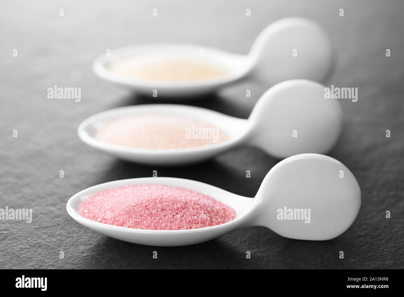 Red, orange and yellow instant jelly or jello powders on small spoons ...