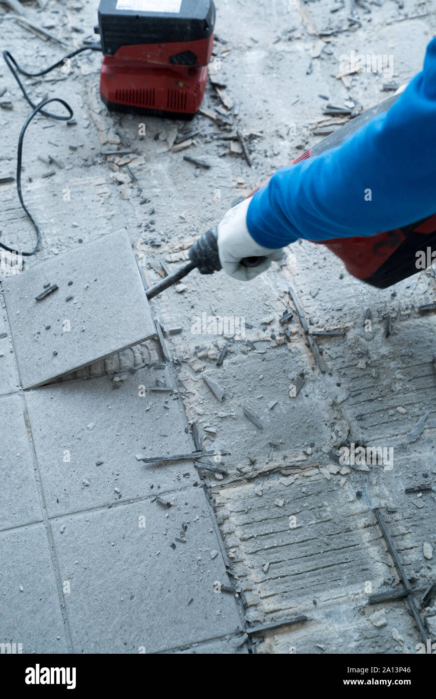detail view of a construction worker using a handheld demolition hammer ...