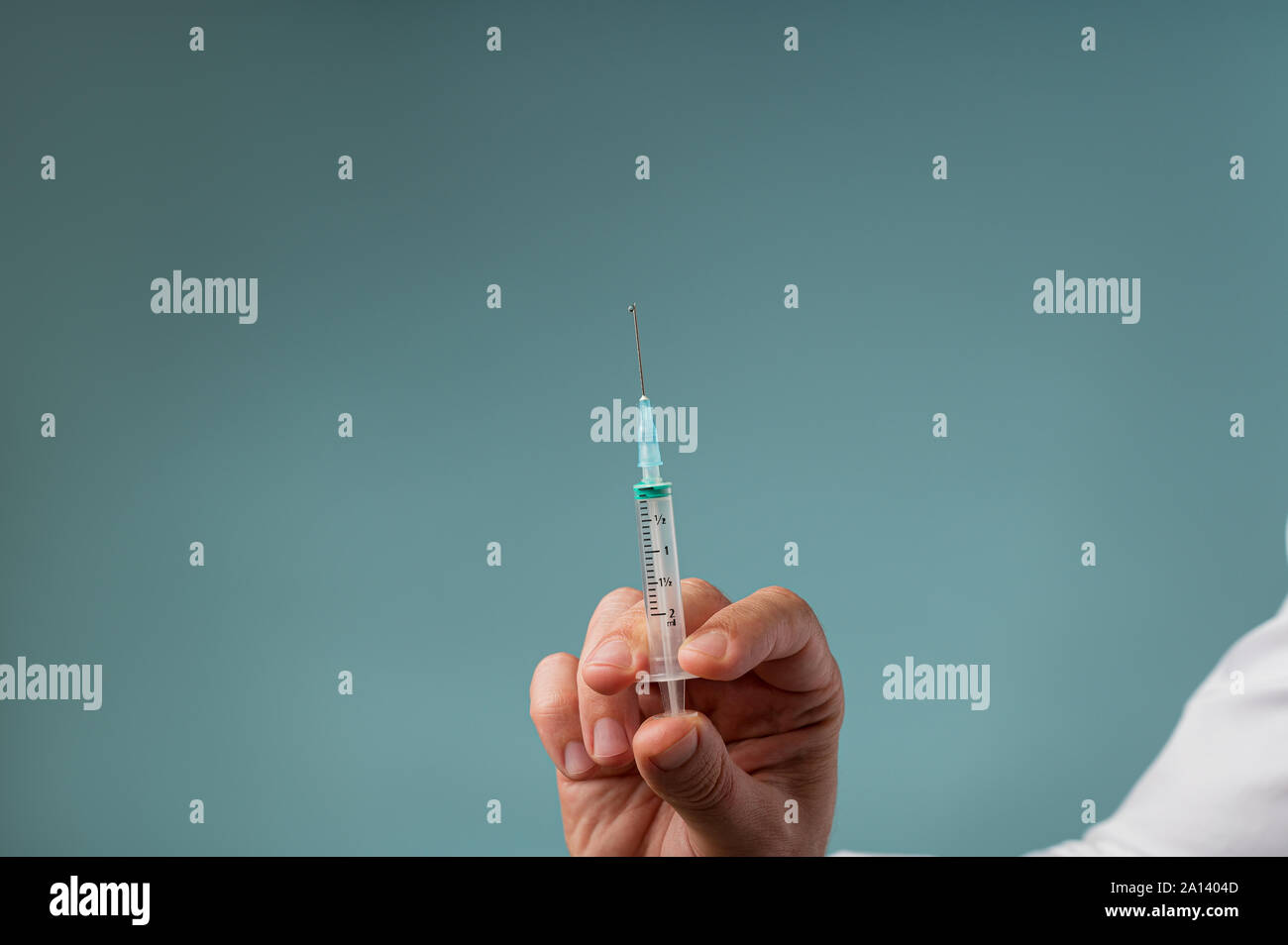 Hand of a doctor holding an injection with a needle in a concept of ...