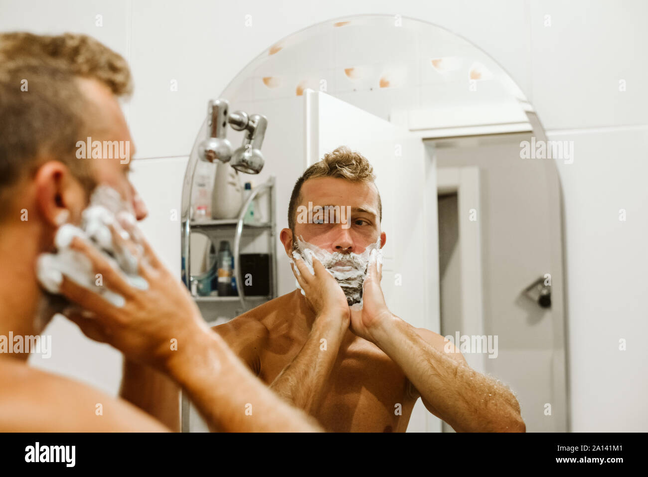 Man shaving face in bathroom mirror Stock Photo - Alamy