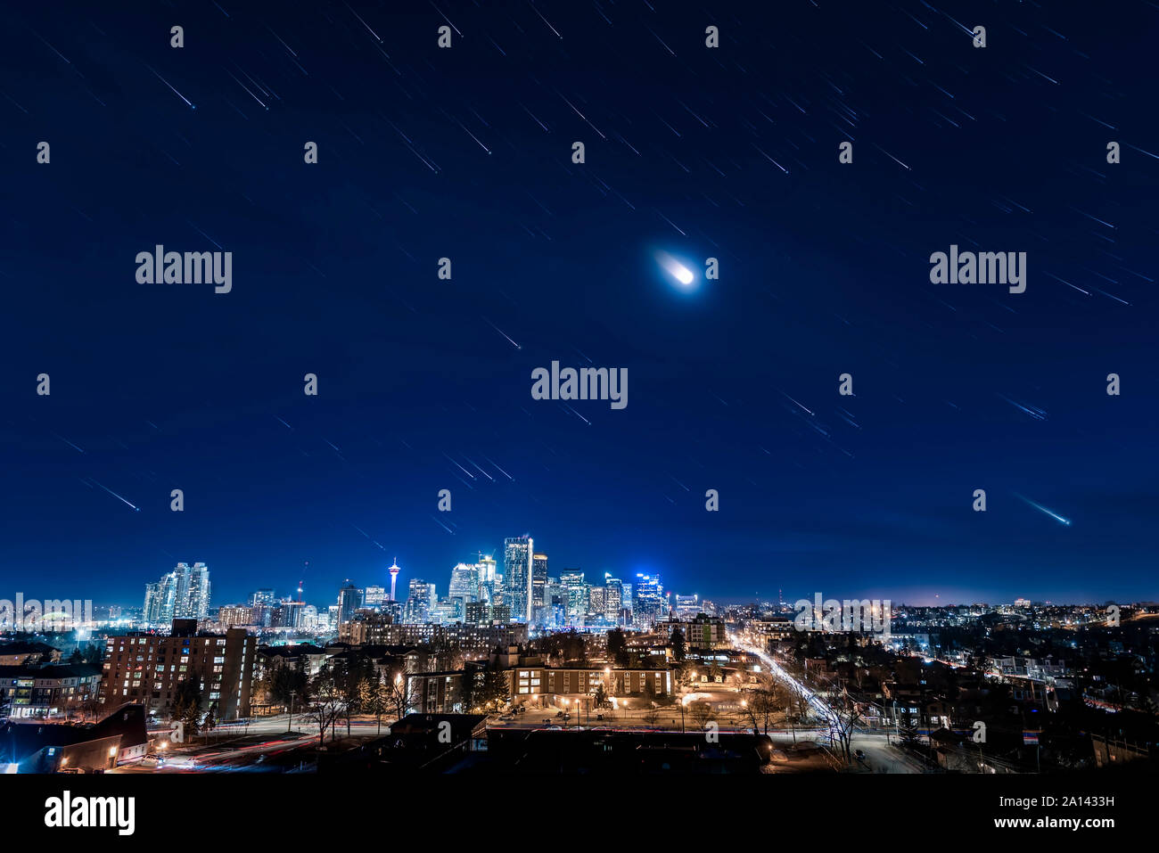 Star trails of Orion, the moon, and the stars of winter over downtown ...