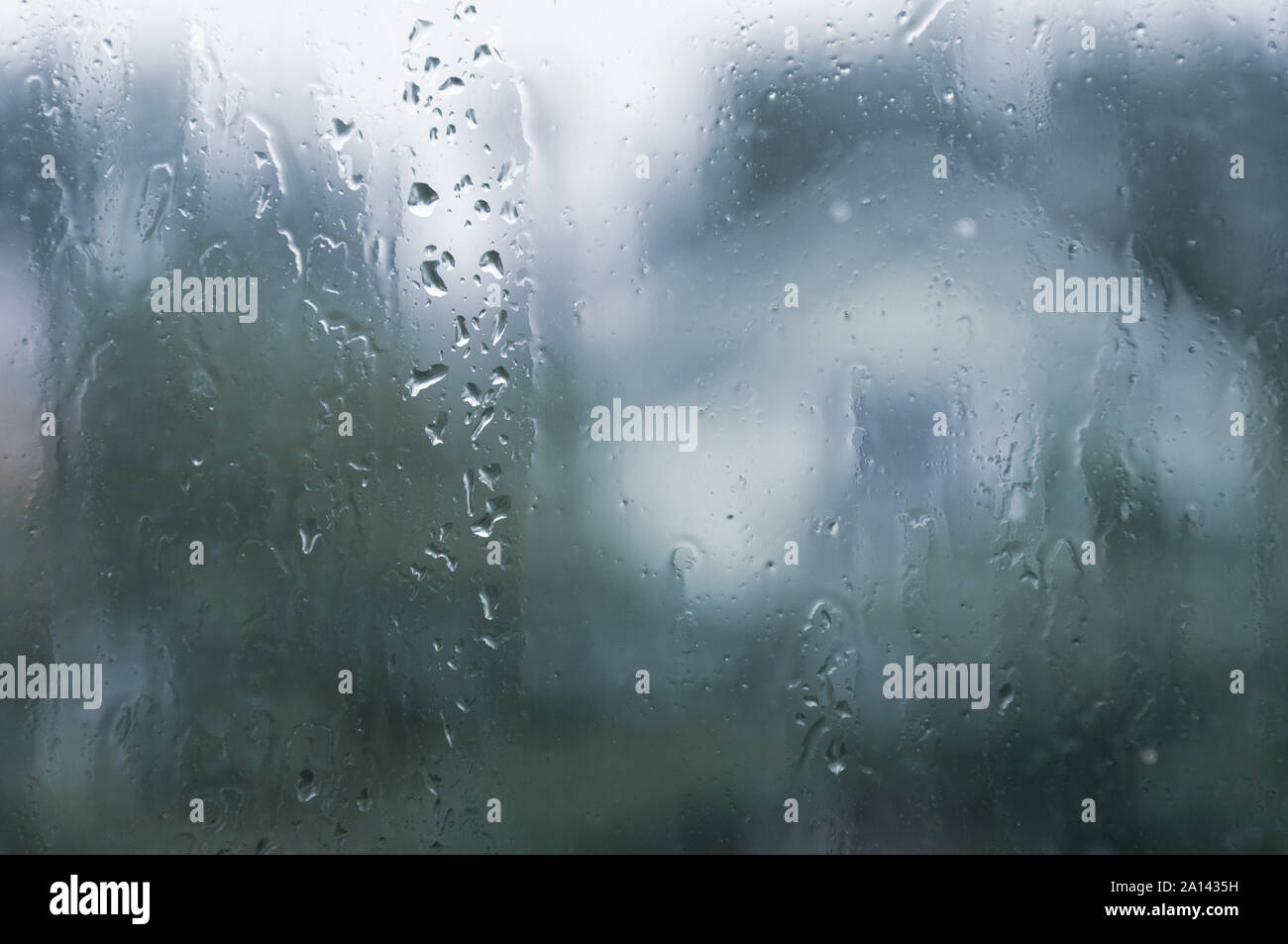 wet glass of window with raindrops, estate garden, view through window ...