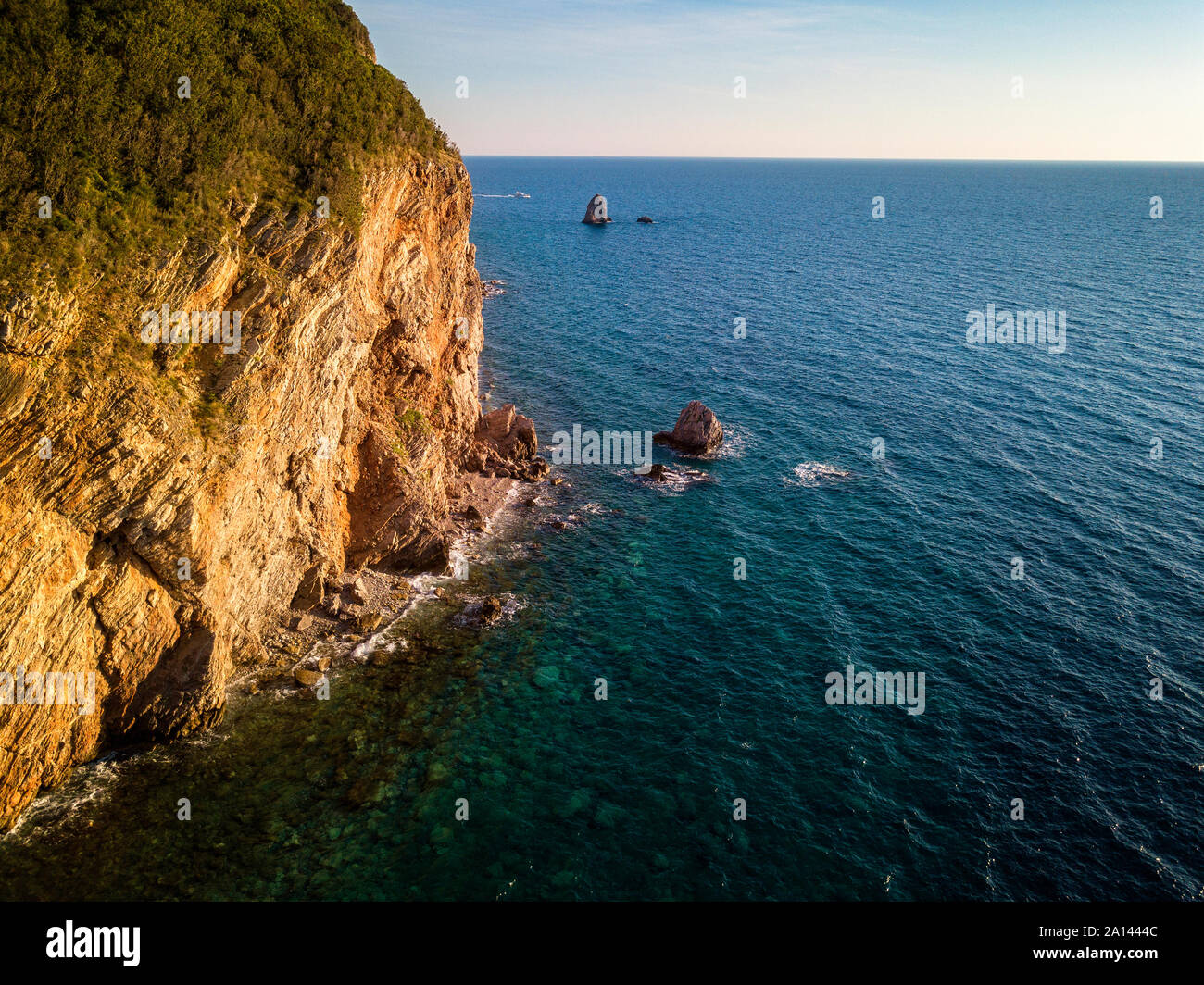 Aerial view of Buljarica promontory, steep cliff on the coast lapped by ...