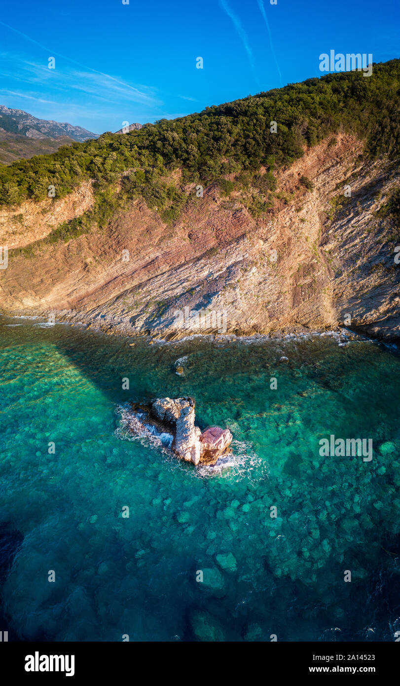 Aerial view of Buljarica promontory, steep cliff on the coast lapped by ...