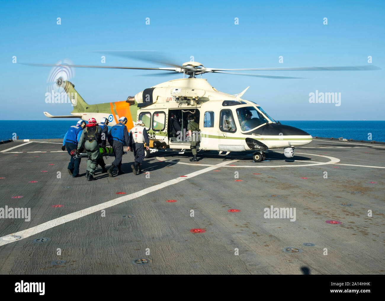 Sailors carry a simulated casualty to an AW-139 rescue helicopter Stock ...