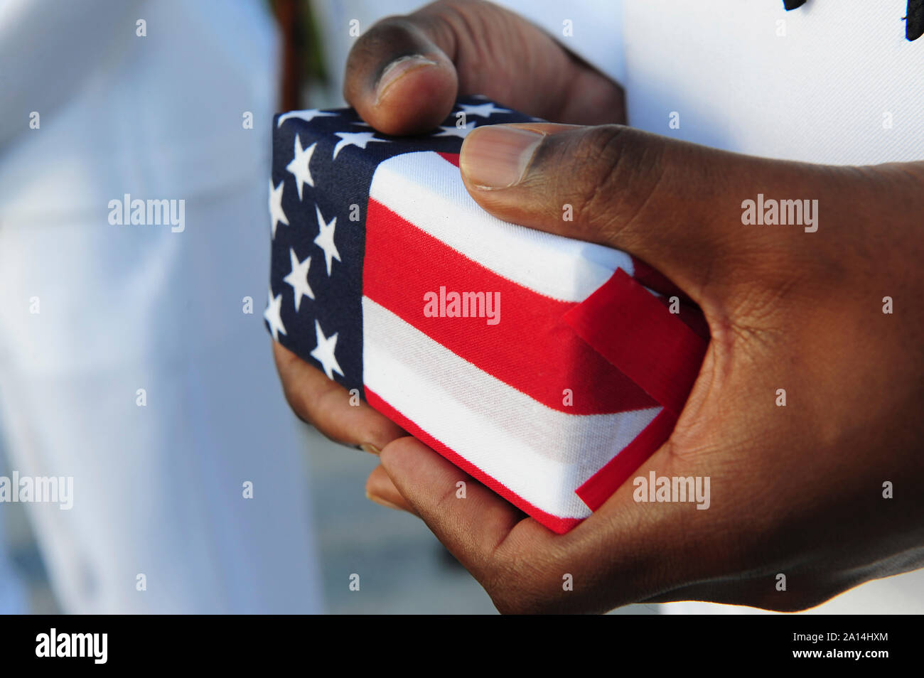 A sailor holds a box of ashes during an ash scattering ceremony at the ...