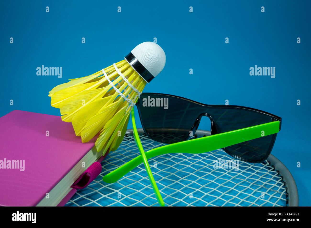 Colorful badminton shuttlecocks with racket and sunglasses resting on a ...