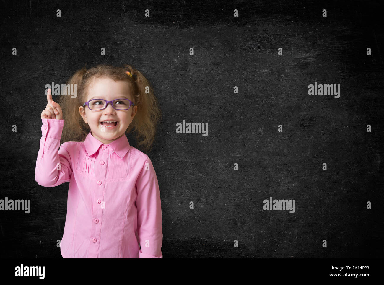 Smilling kid inventor with rised hand thinking and finding idea near ...