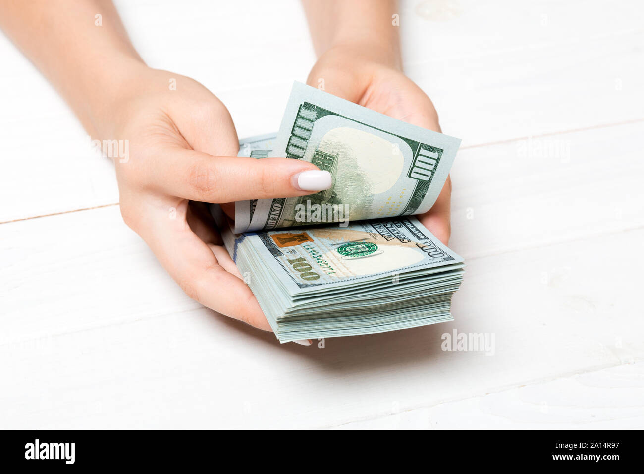 Perspective view of female hands counting money. One hundred dollar ...
